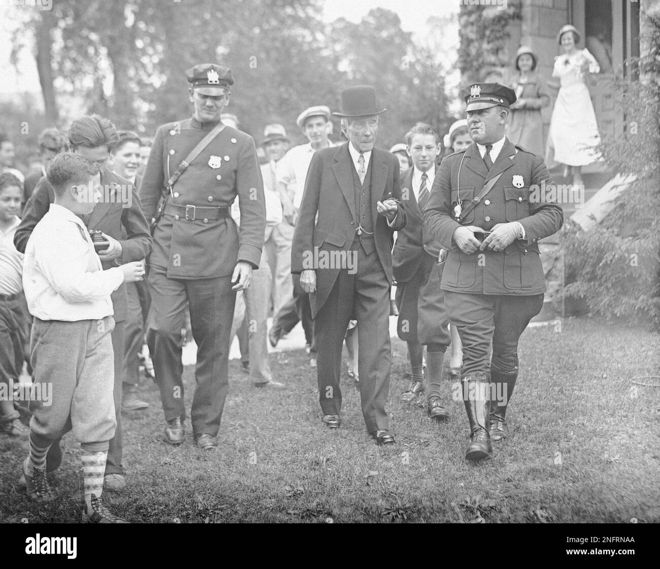 John D. Rockefeller, Sr. is surrounded by state troopers and youthful ...