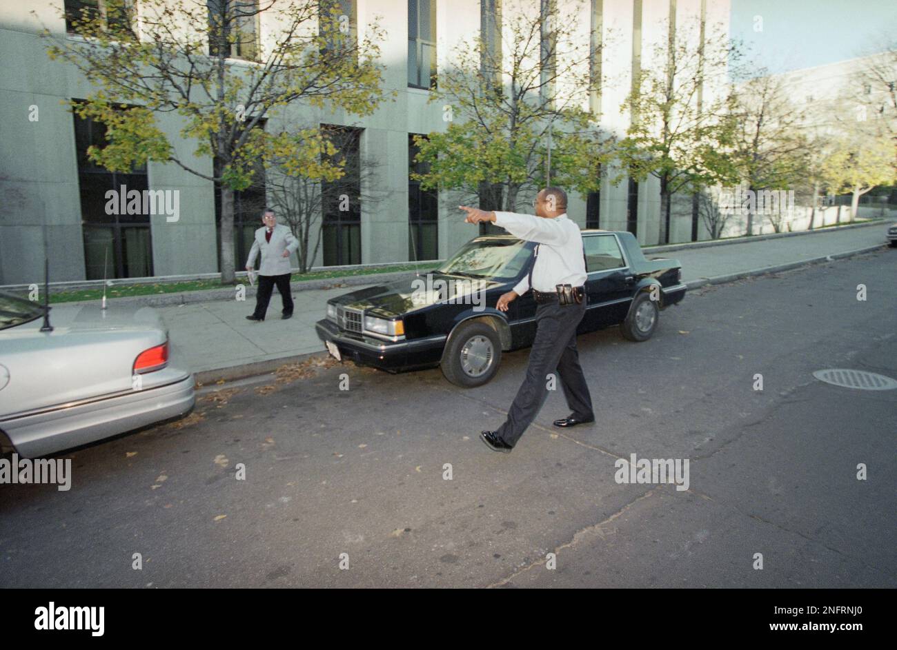 A police officer directs a pedestrian away from police headquarters on ...