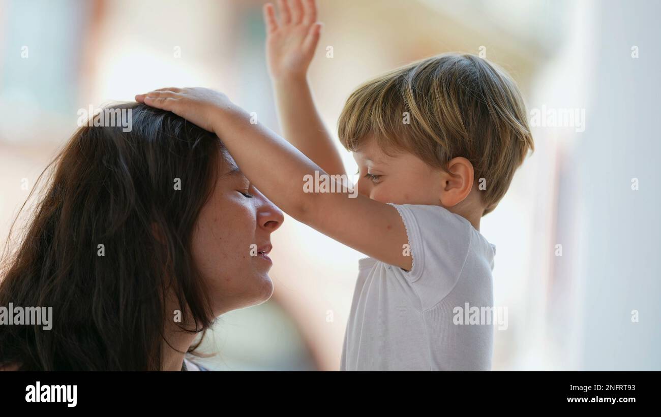 Parenting stress. Patient mother. Little boy hitting parent in the head ...