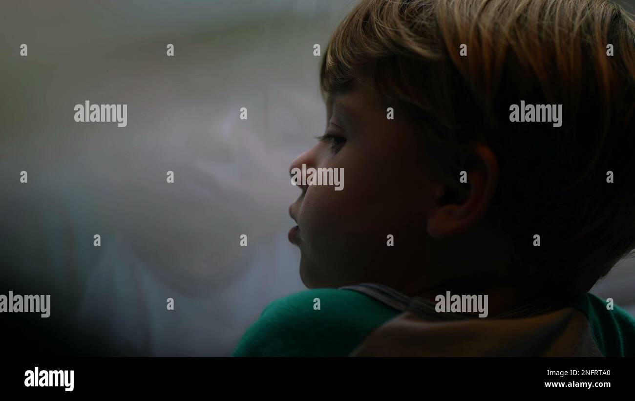 Pensive child traveling by train entering tunnel. Thoughtful small boy ...