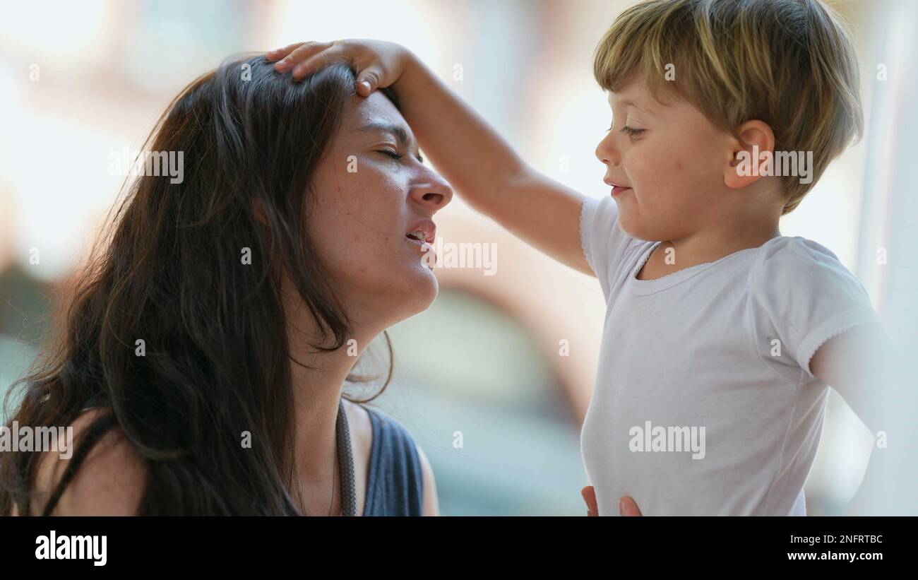 Parenting stress. Patient mother. Little boy hitting parent in the head ...