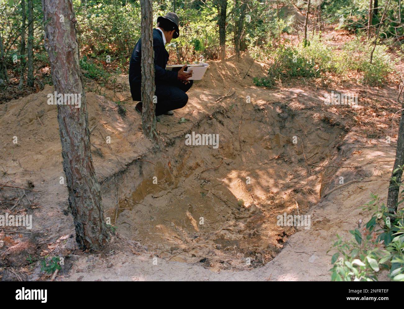A newspaper reporter looks over the grave site of kidnapped Exxon ...