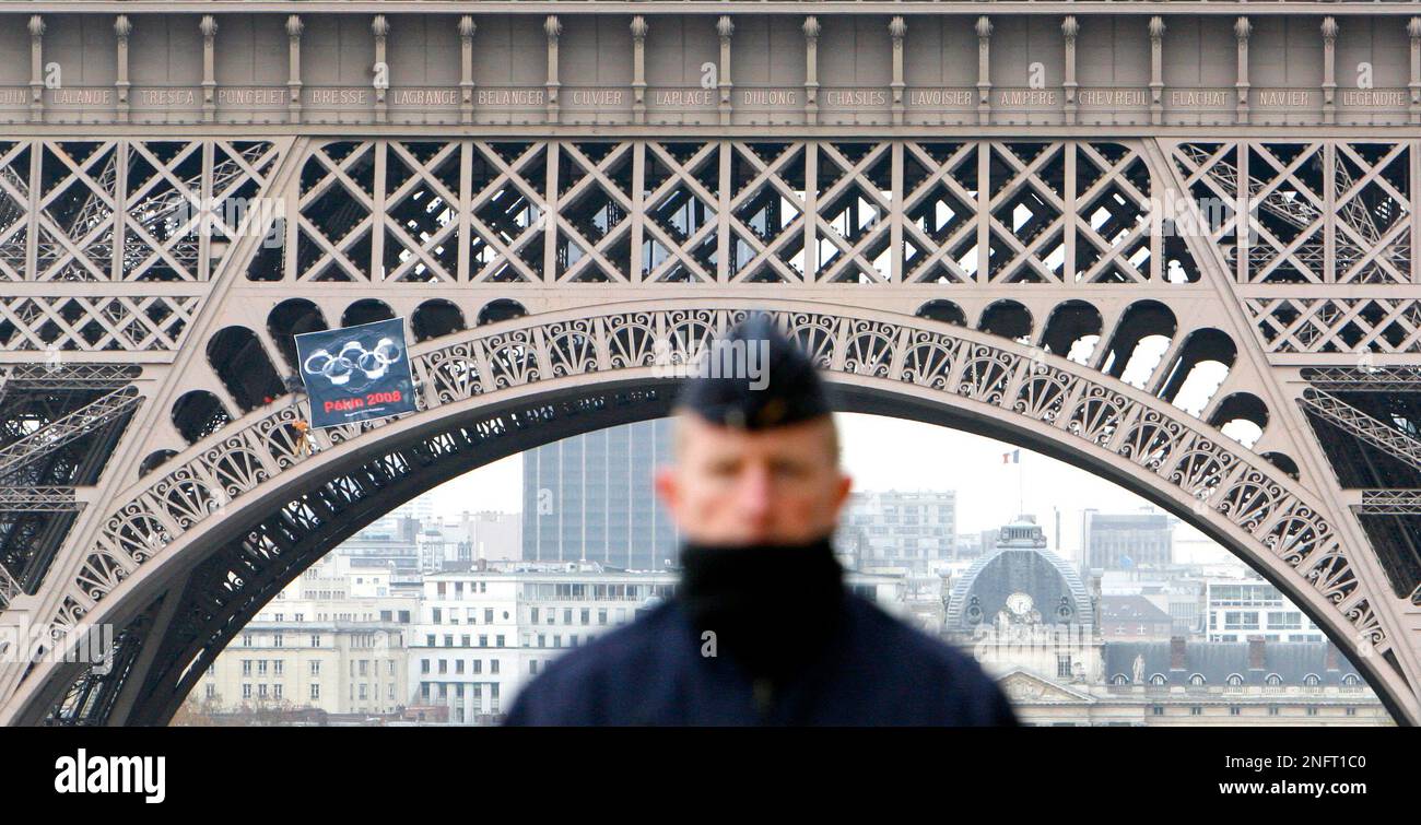 A banner, a black flag with the five Olympic rings depicted as ...