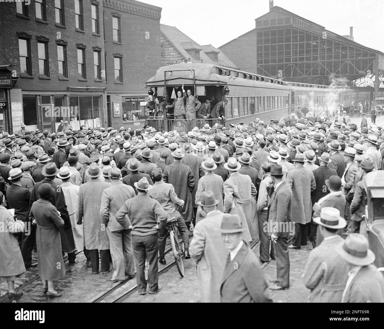 A crowd greets Gov. Franklin D. Roosevelt, seen waving from back of ...