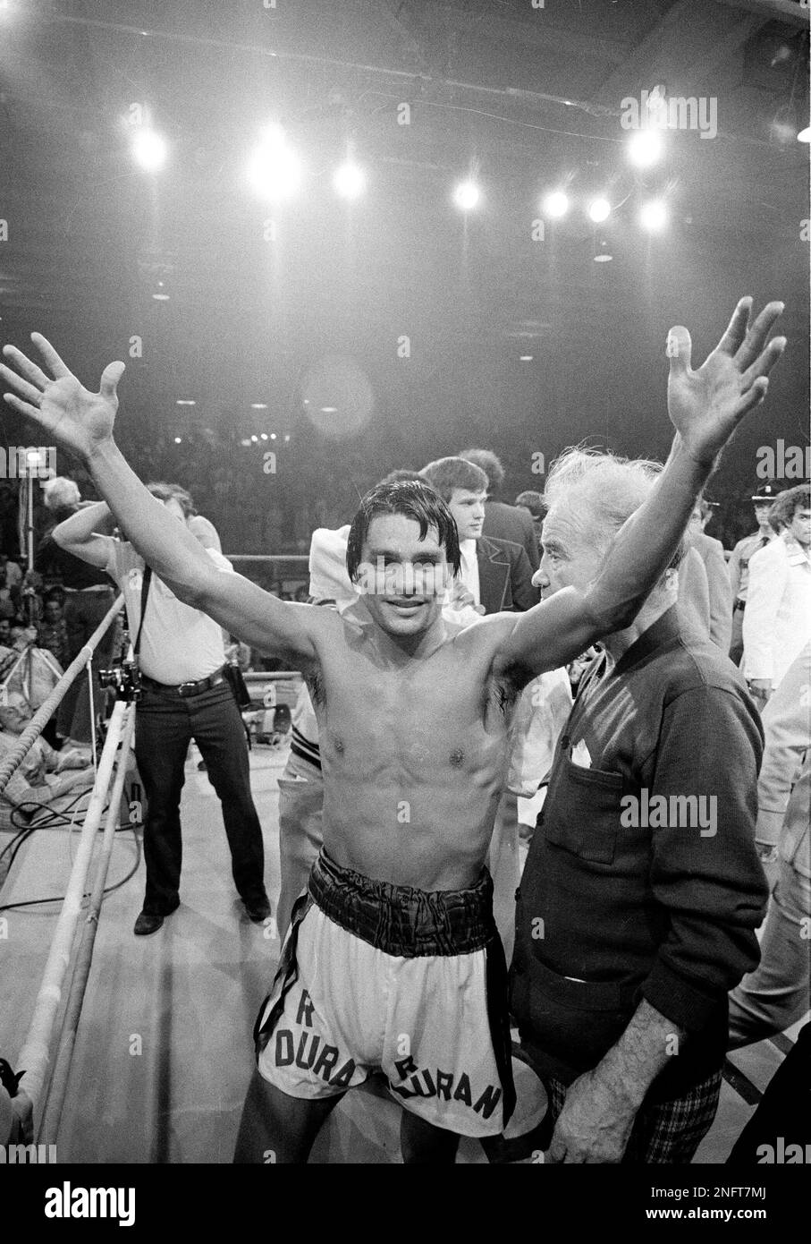 Boxer Roberto Duran raises his arms in victory as he passes his trainer ...