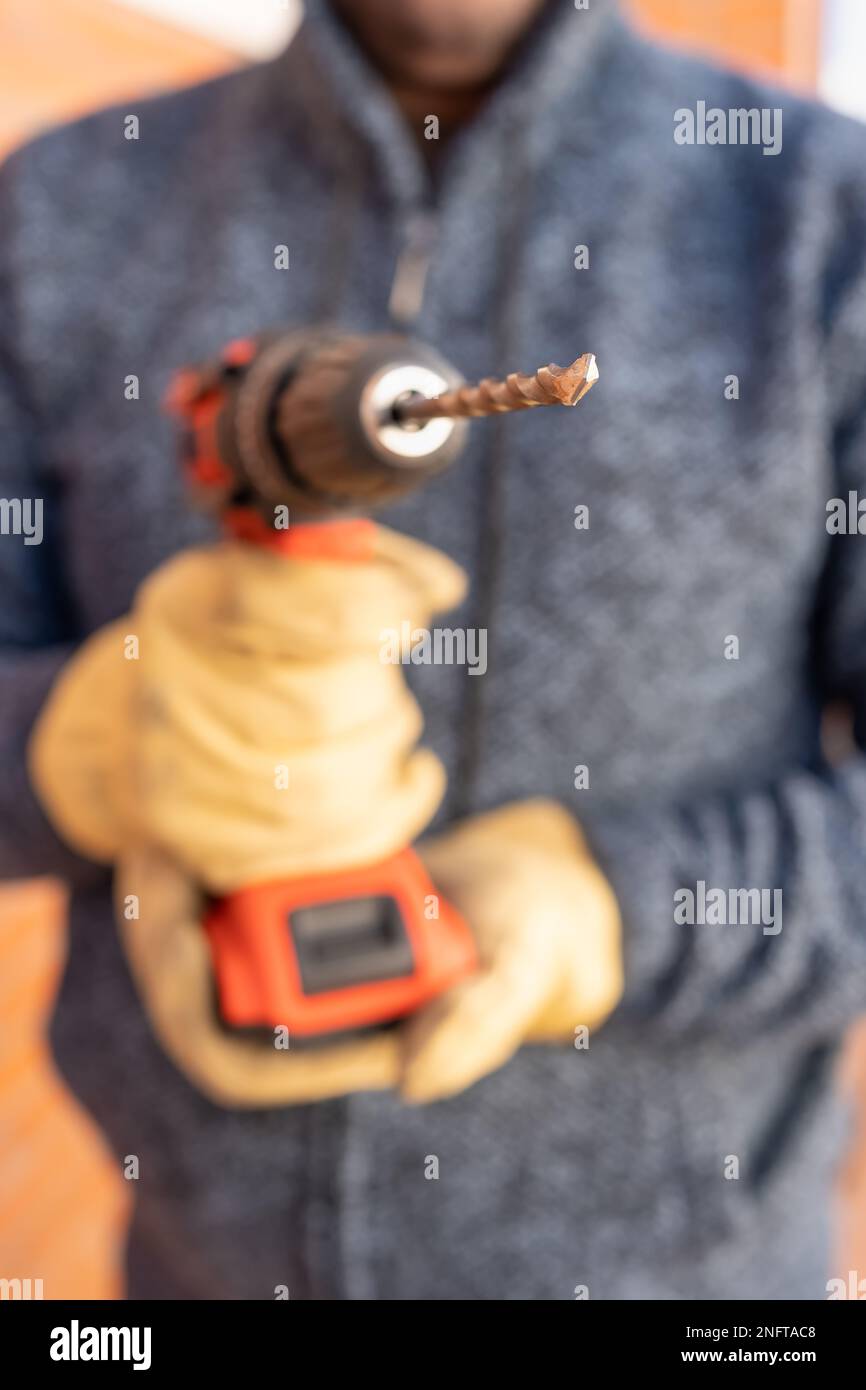 Electric drilling machine held by the hands of a working man ...