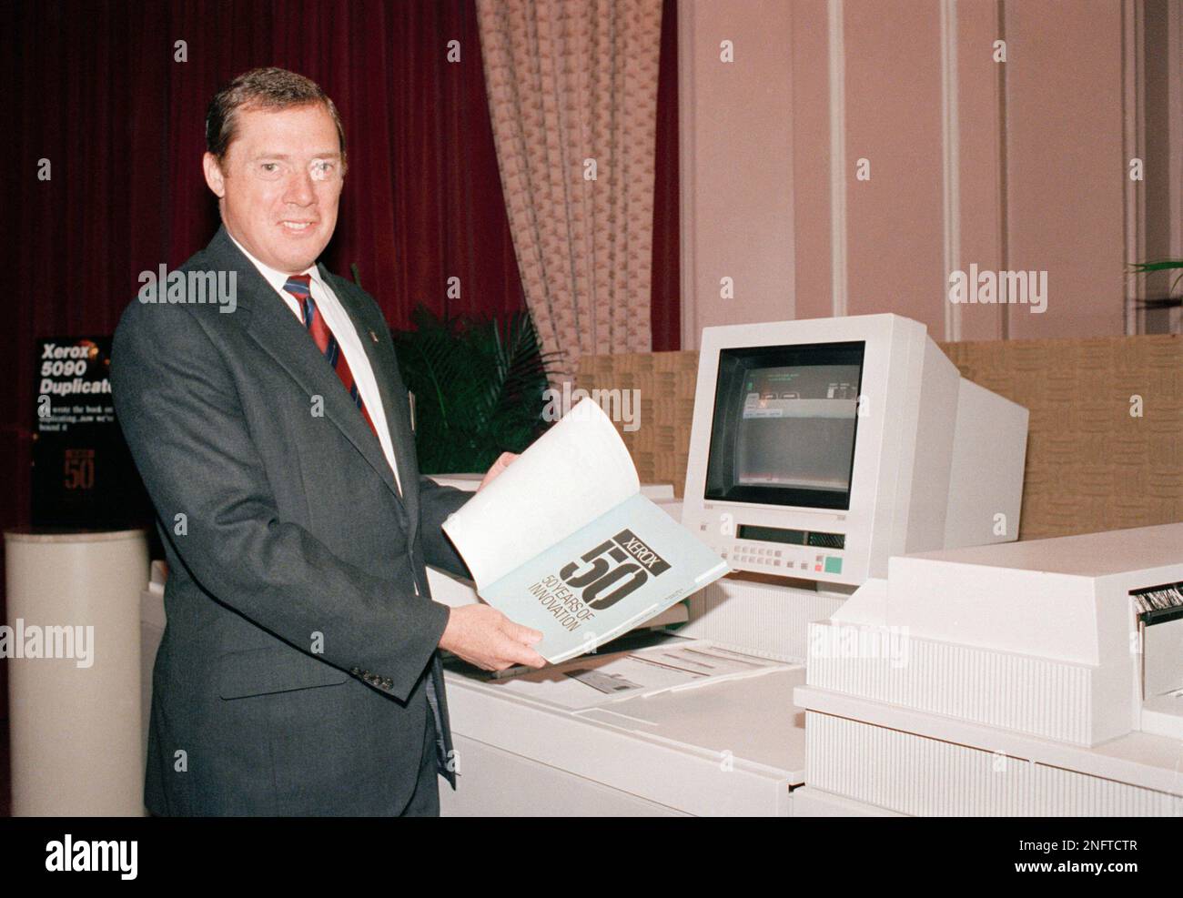 Xerox President Paul Allaire poses besides the new Xerox 5090 ...