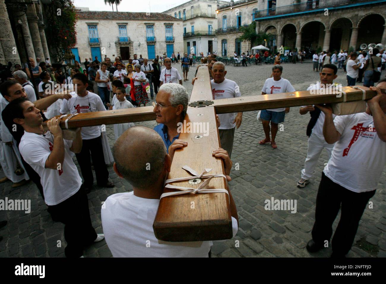 Catholic faithful carry a wooden cross in Good Friday procession in ...