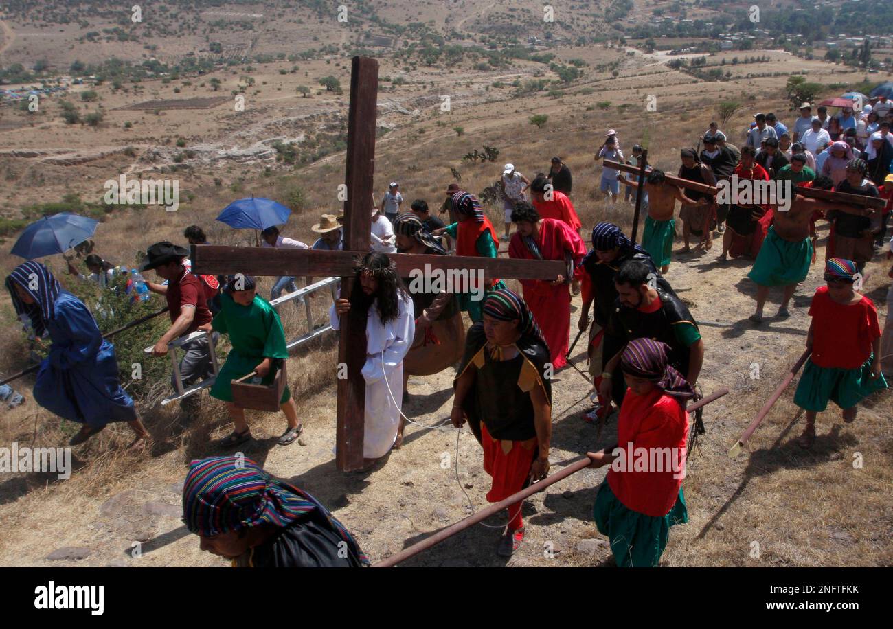 Juan Carlos Longoria, portraying Christ, carries a cross during the Via ...