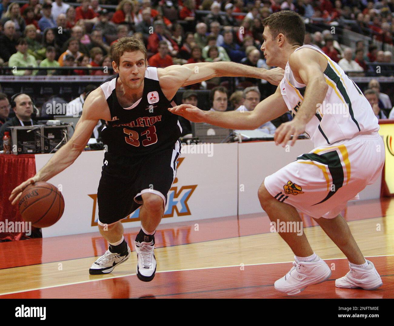 Carleton University Ravens' Rob Saunders, left, dribbles the ball ...