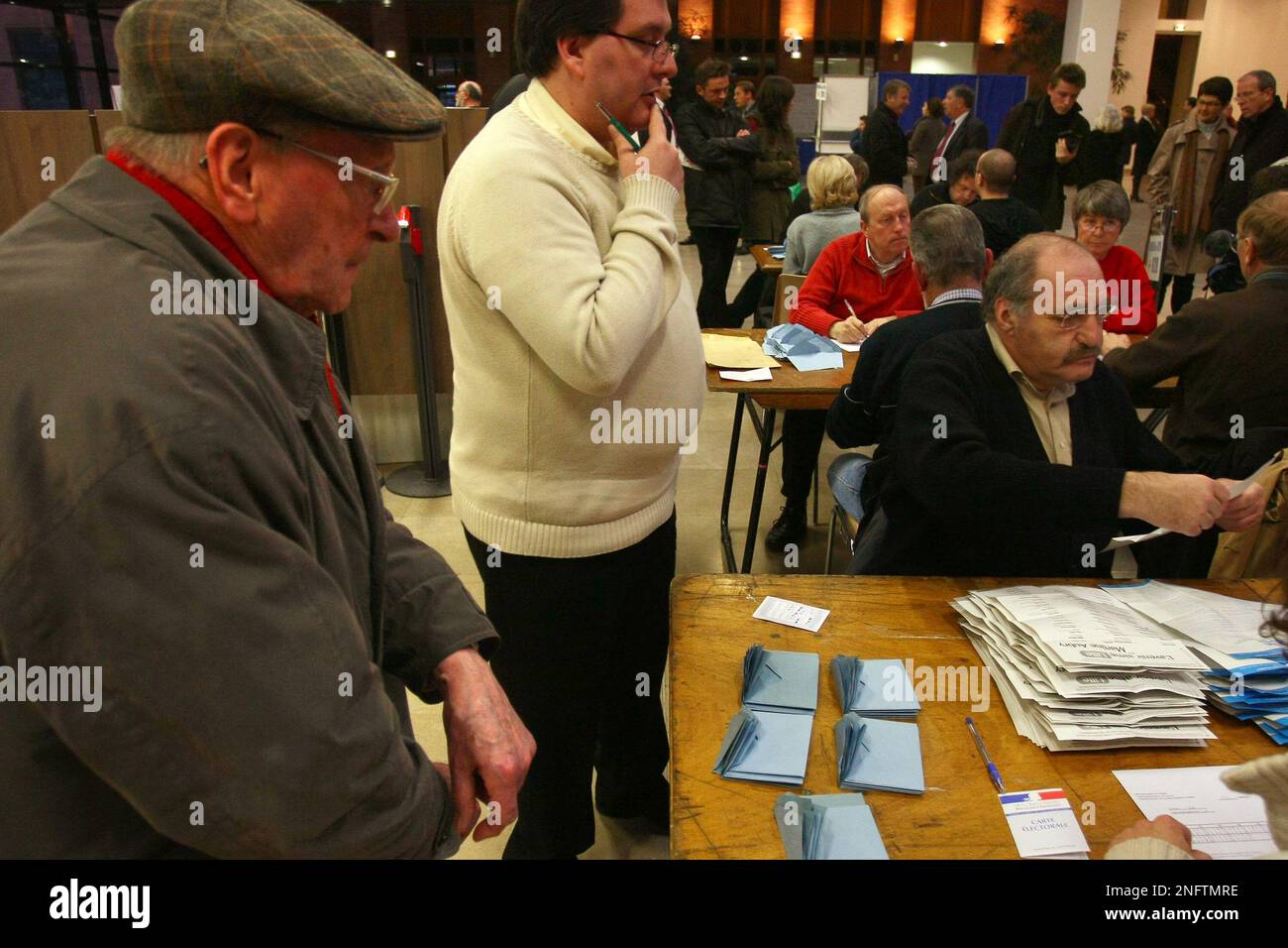An elderly man, foreground, watches people count votes in a Lille ...