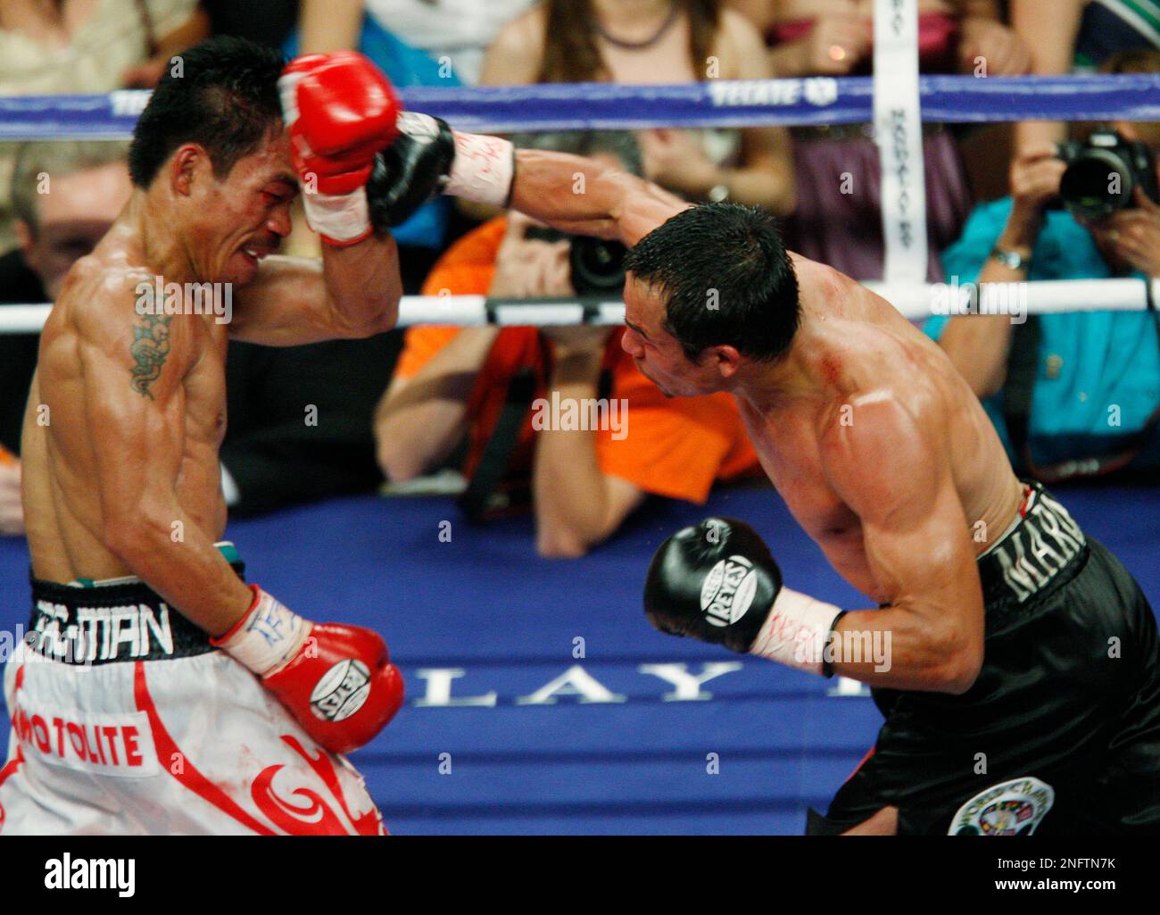 Manny Pacquiao, of the Philippines, left, takes a punch from Juan ...