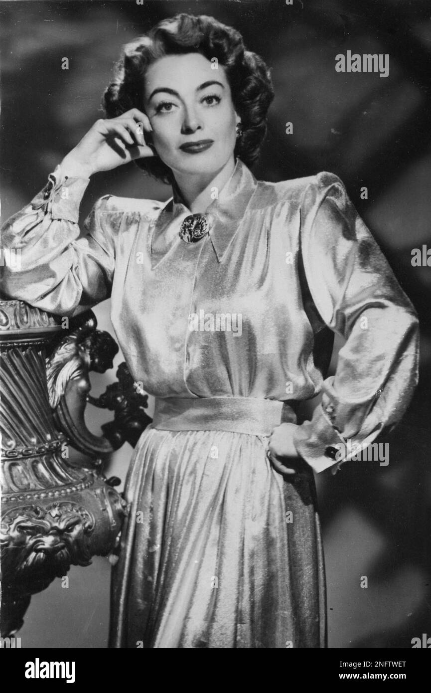 Actress Joan Crawford, models a this glamorous gold lame shirtwaist ...