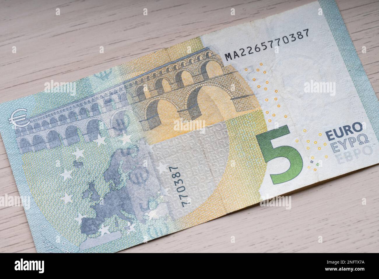 5 euro banknote close up, wooden table background for business finance ...