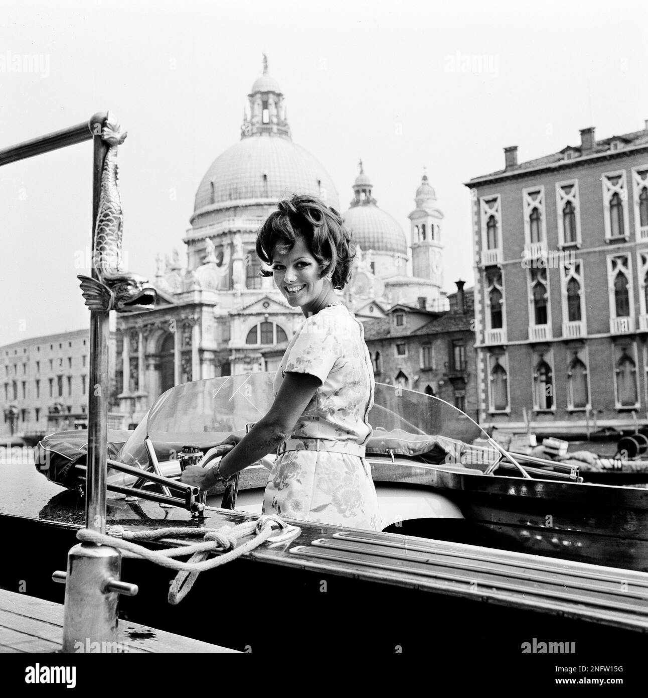 Italian actress Claudia Cardinale stands at the wheel of a motorboat on ...