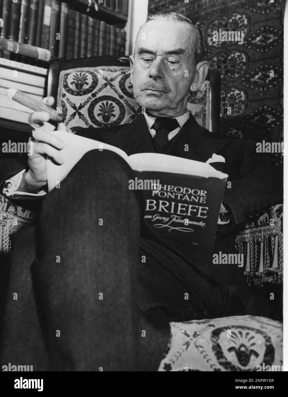 German dissident author, Thomas Mann sits in his study, reading the ...