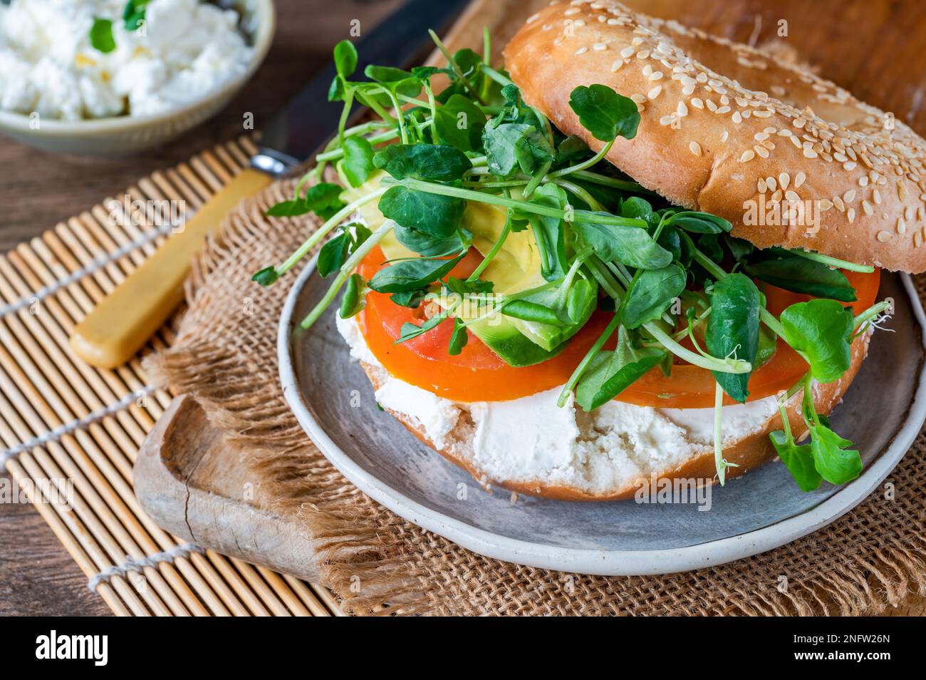 Vegetarian sesame bagel with cream cheese, tomato, avocado and ...