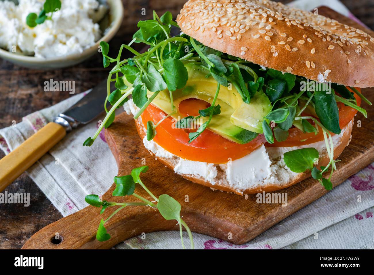 Vegetarian sesame bagel with cream cheese, tomato, avocado and ...