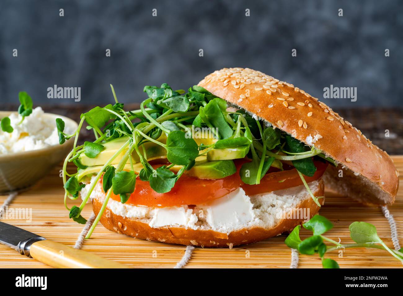 Vegetarian sesame bagel with cream cheese, tomato, avocado and ...