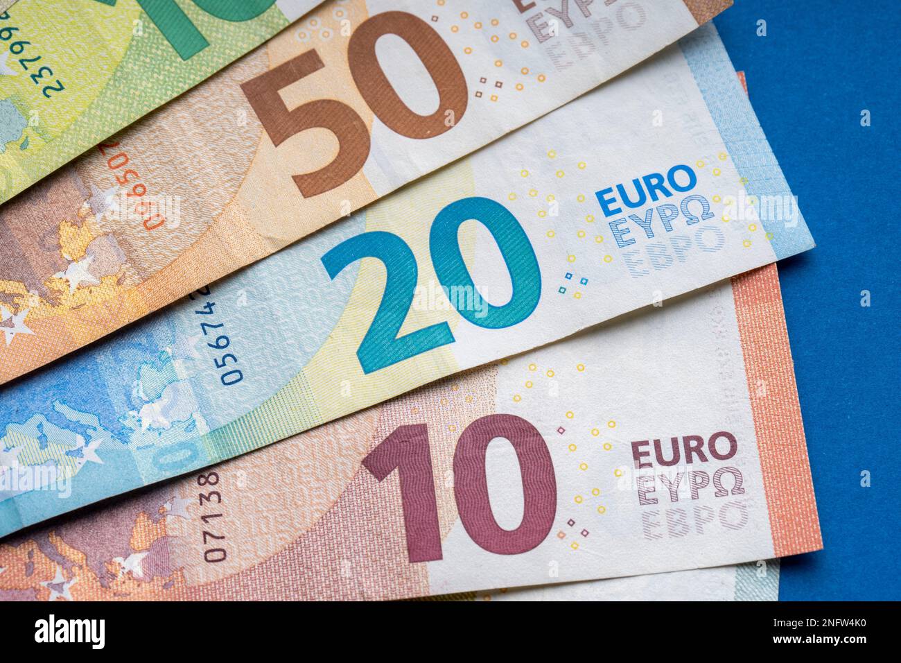 Different euro banknotes in a row close up, blue background for ...