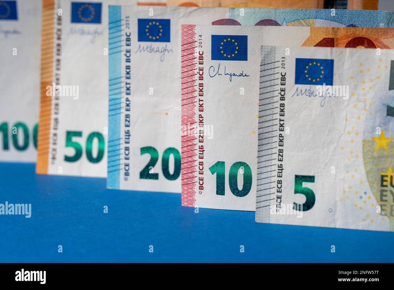 Different euro banknotes in a row close up, blue background for ...