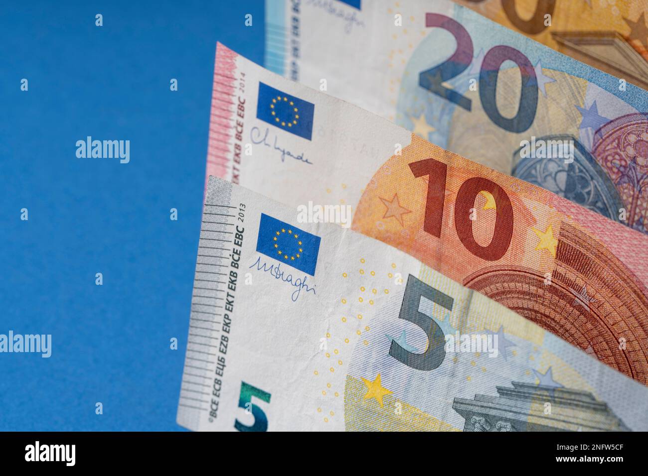Different euro banknotes in a row close up, blue background for ...
