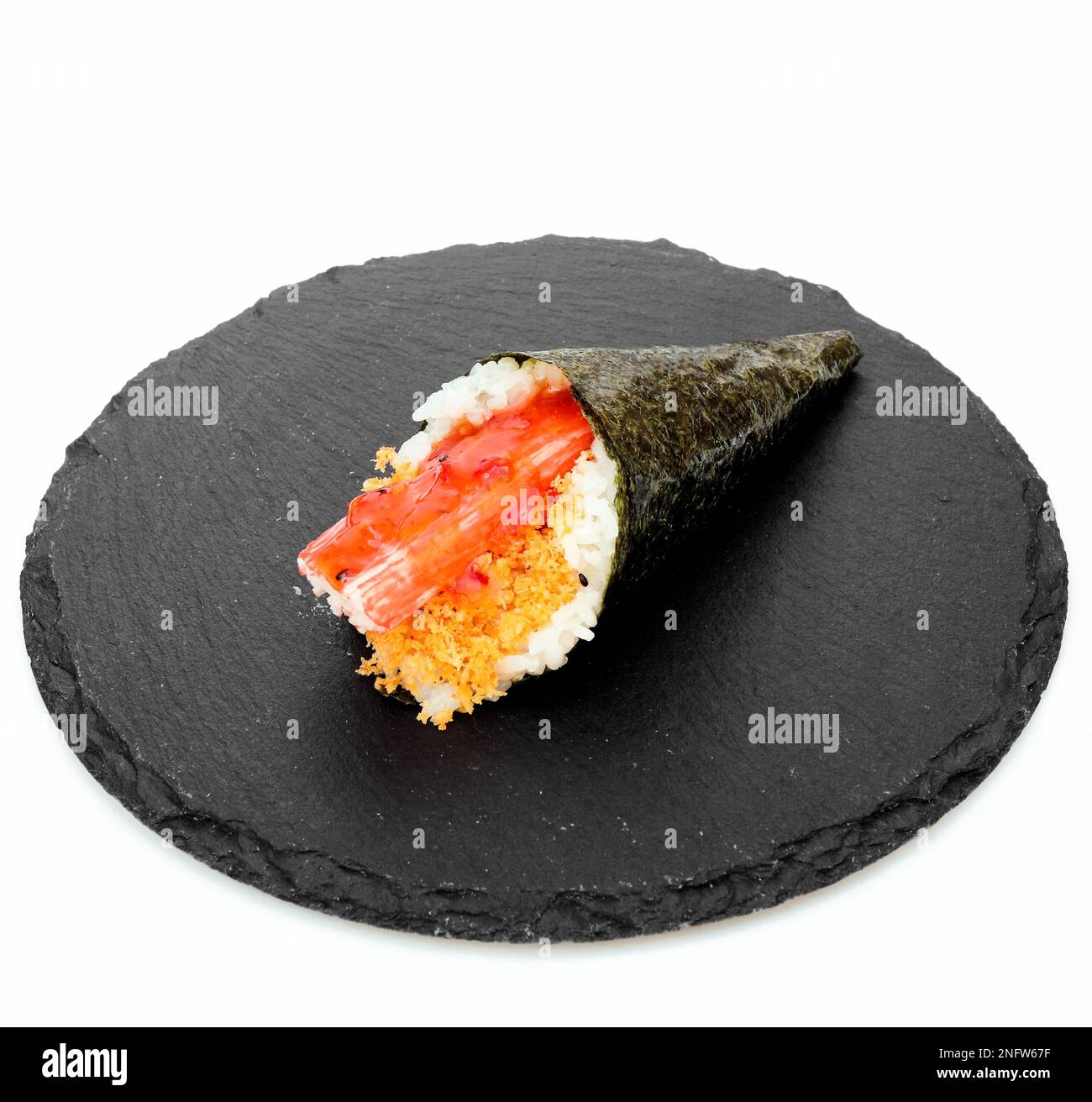 A closeup of one piece of sushi on a black round board isolated on ...