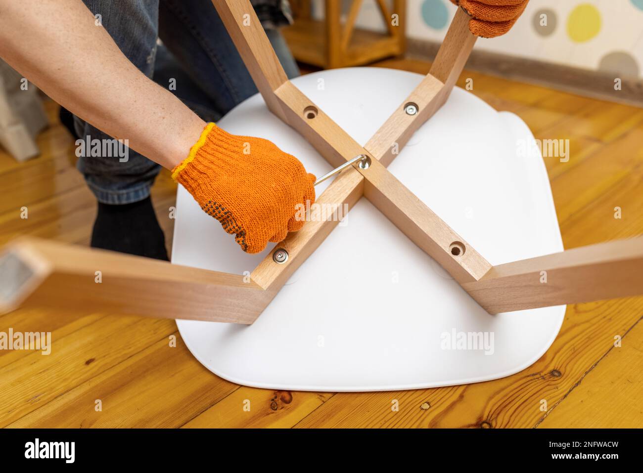 Self-assembly furniture concept. The young man himself assembling ...