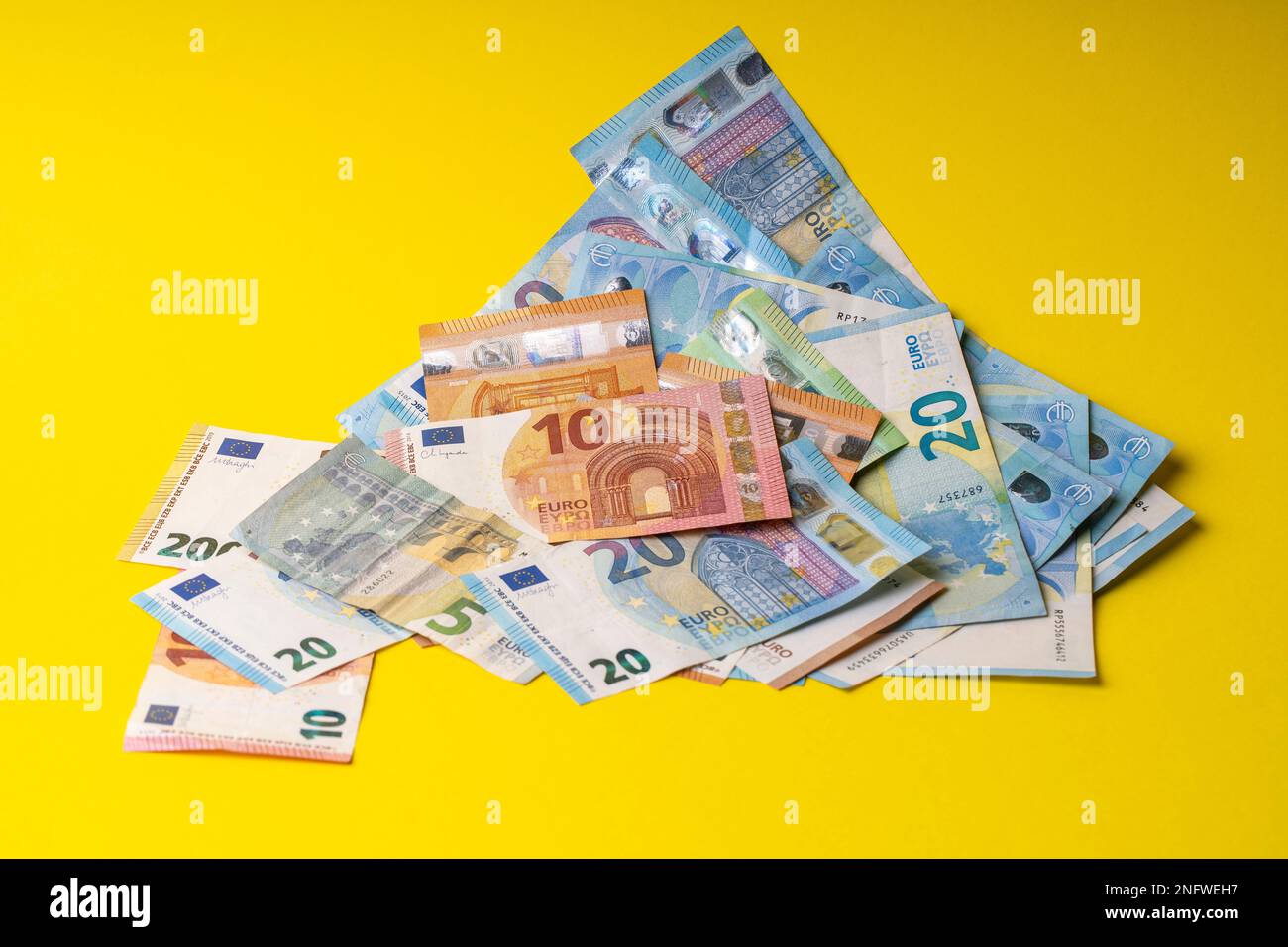 On the table is a pile of banknotes in denominations of five, ten ...