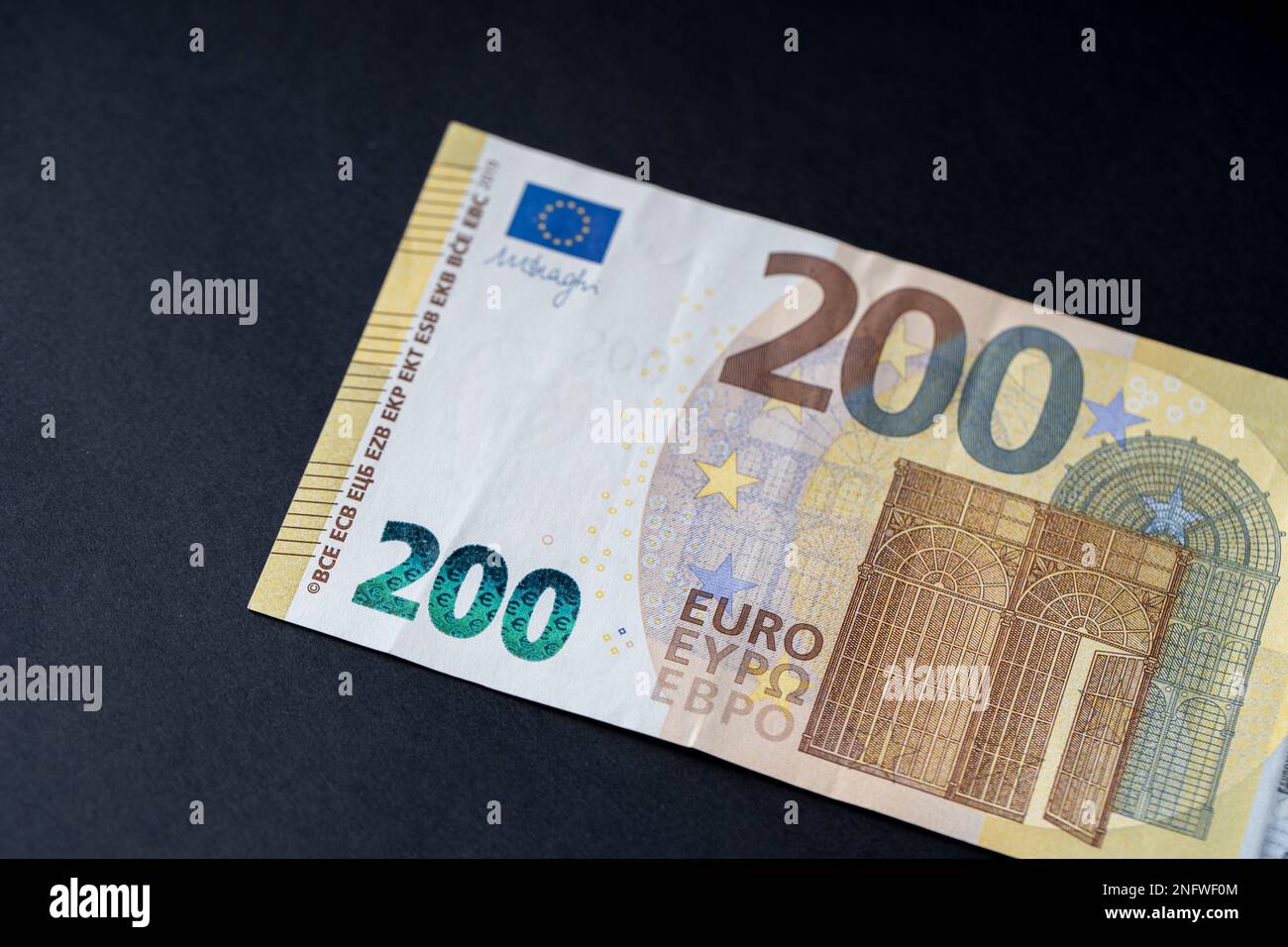 200 euro banknote close up on black background for business finance ...