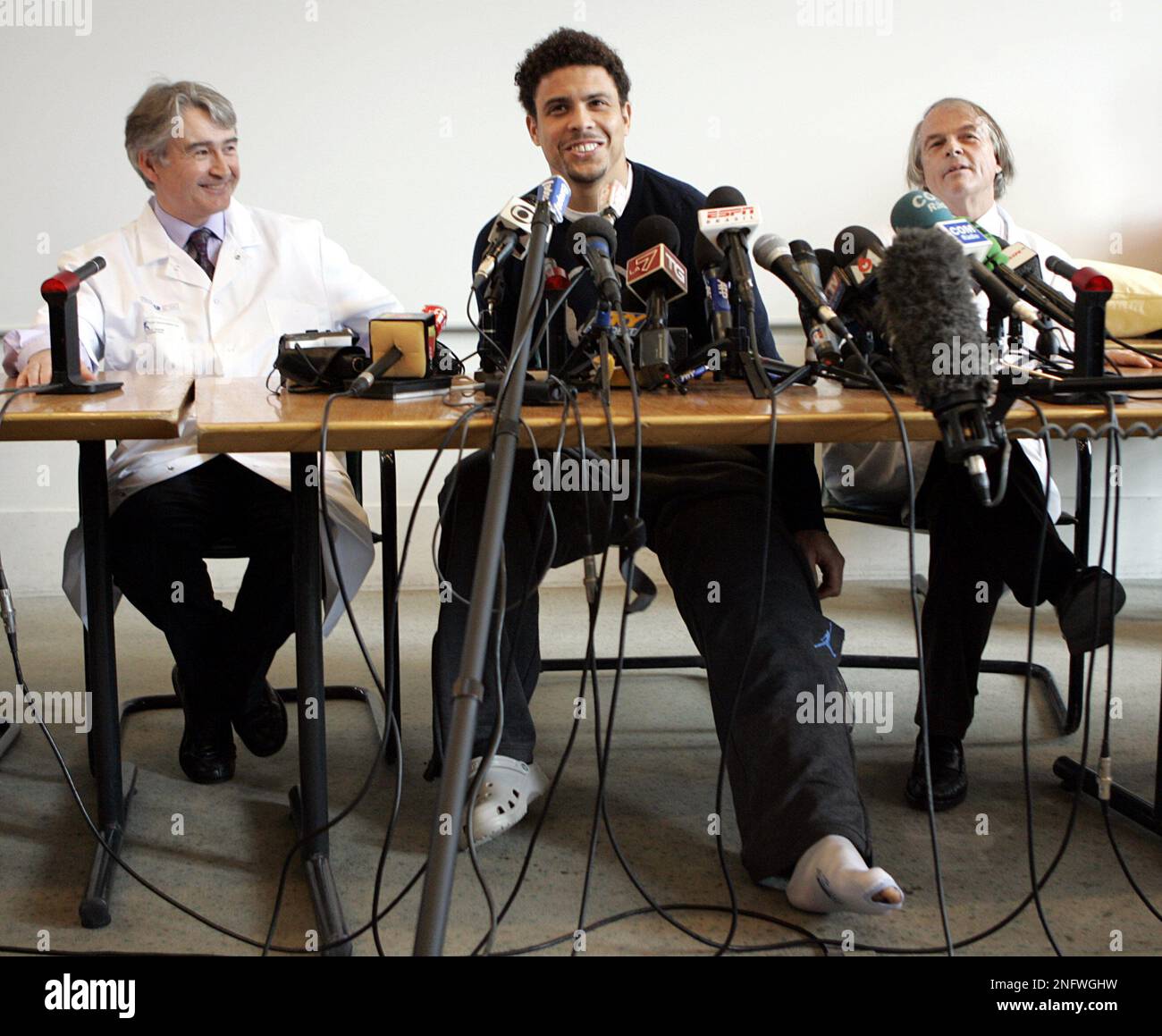 AC Milan striker Ronaldo, center, is flanked by surgeons Eric Rolland ...