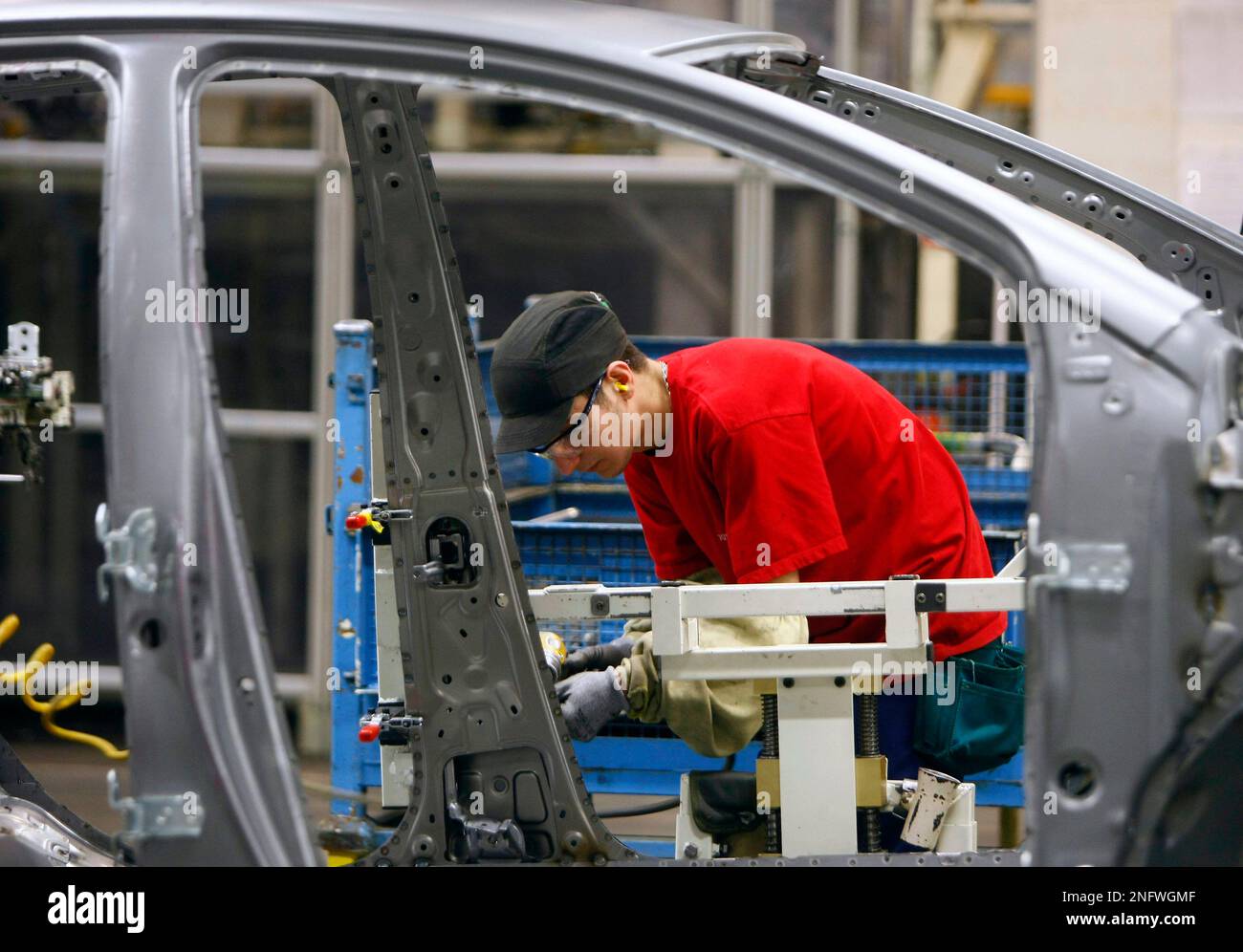 An employee works on a Toyota Yaris car on the assembly line at the ...