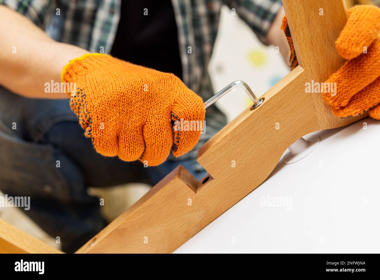 Self-assembly furniture concept. The young man himself assembling ...