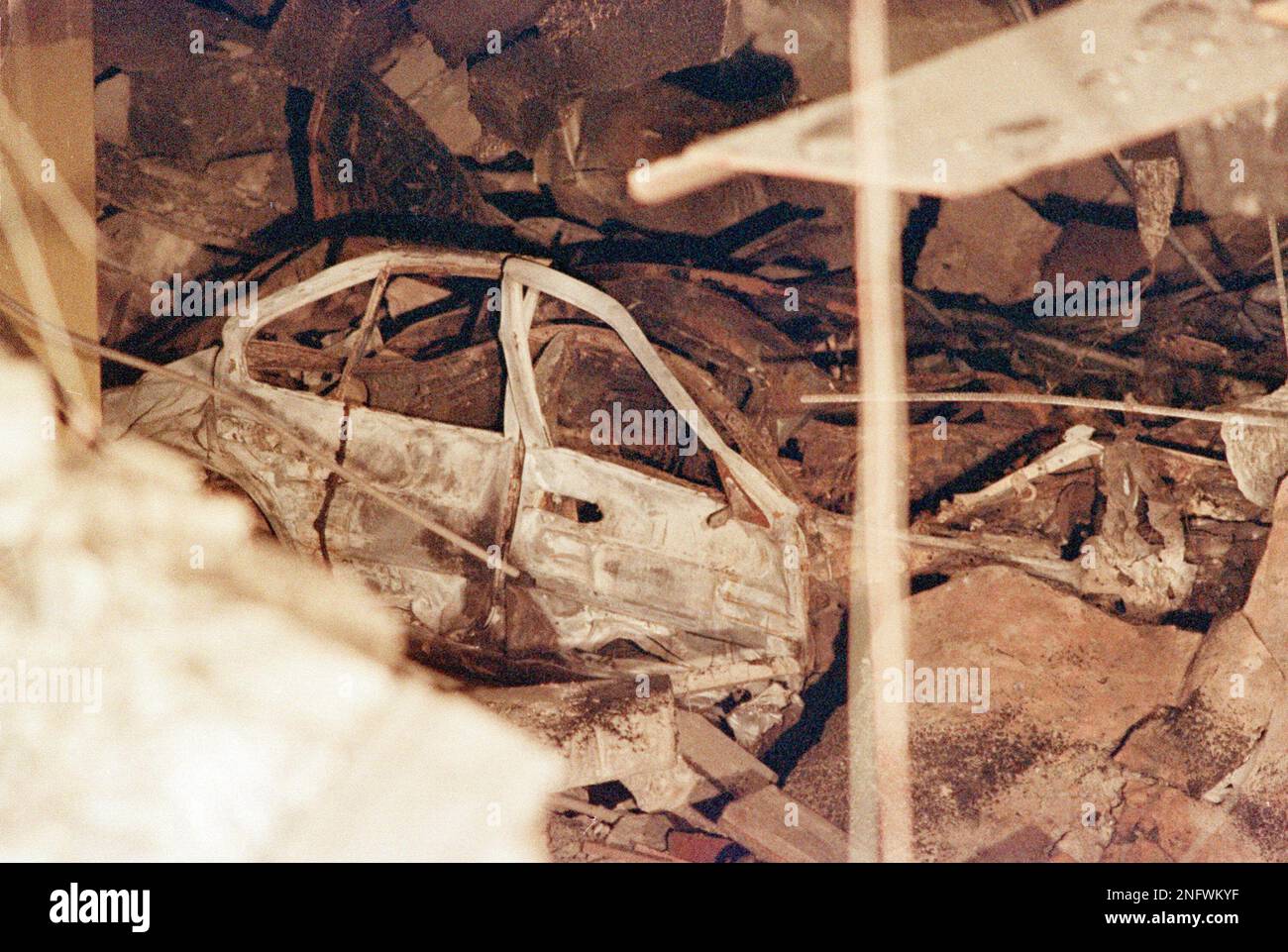 A destroyed car lies underneath a section of rubble in the sub-basement ...