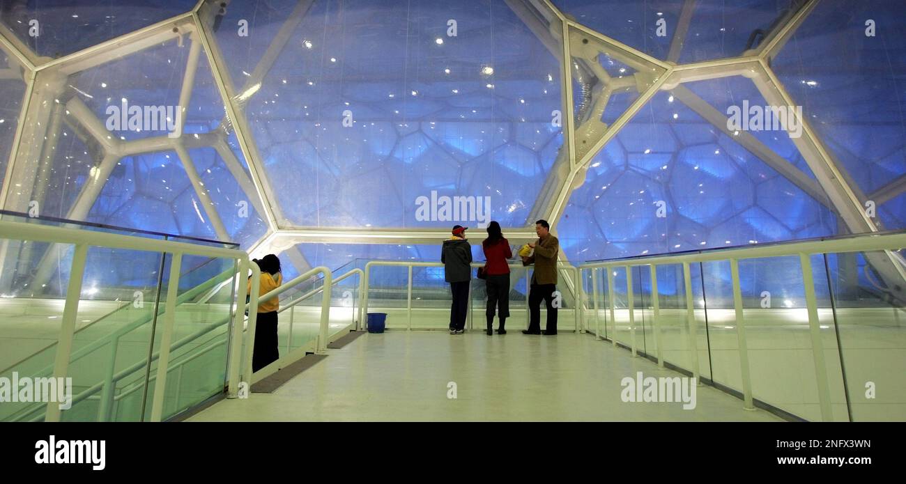 Visitors walk below the translucent wall of the National Aquatics ...