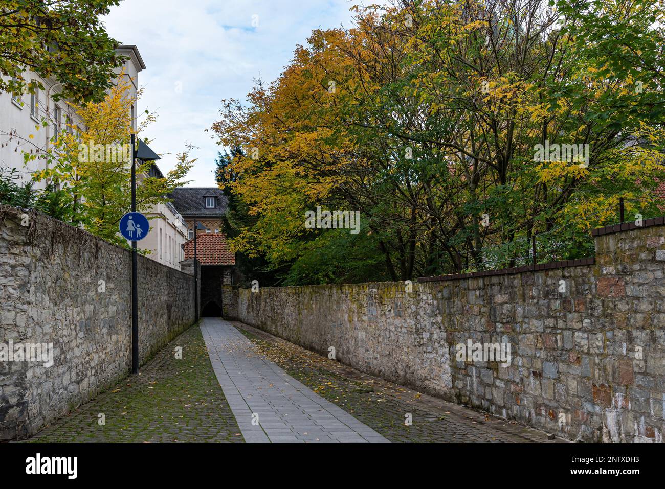 Pedestrian path between two ancient stone walls leading to the ...