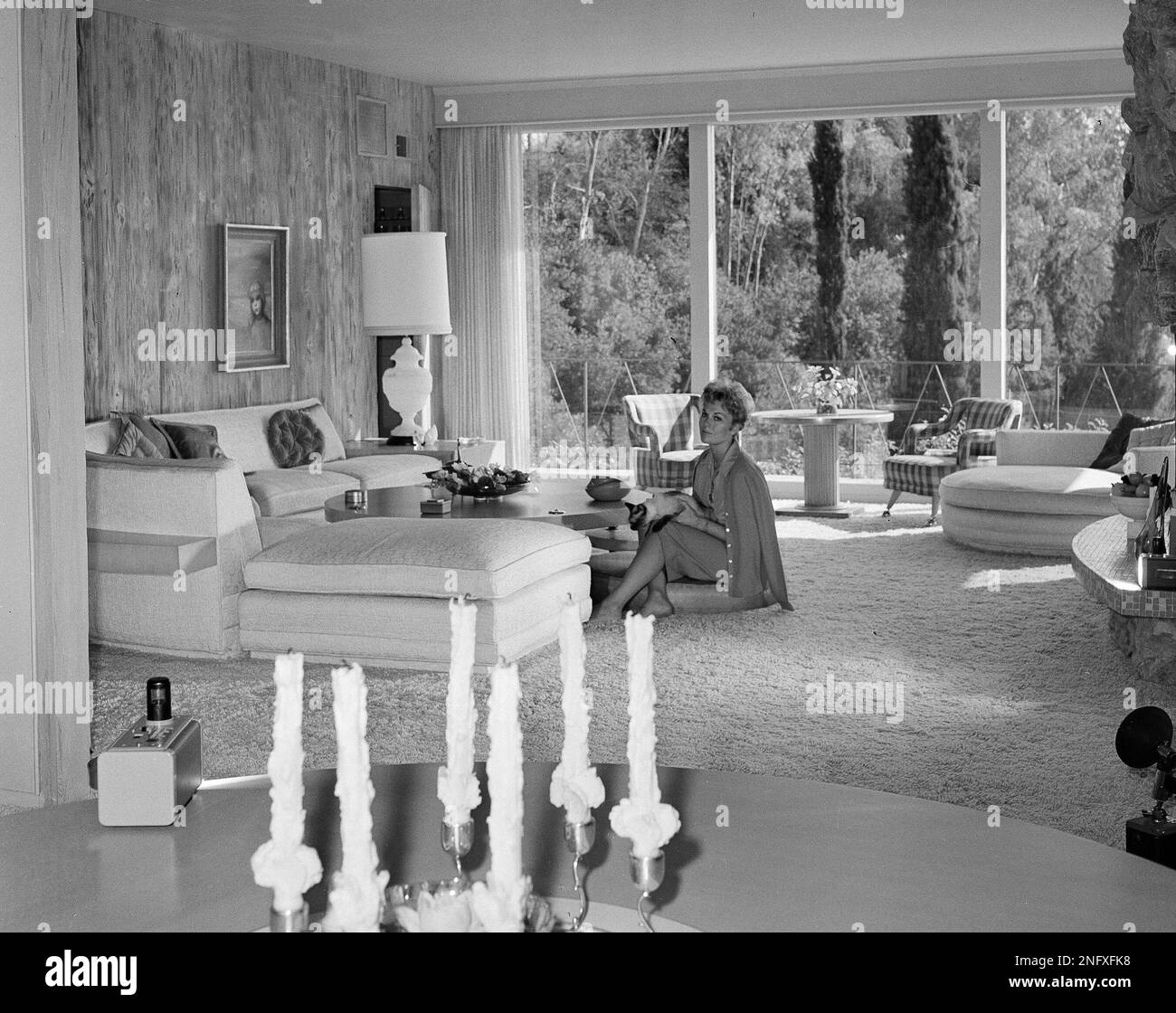Actress Kim Novak has some coffee as she sits on a cushion on her ...