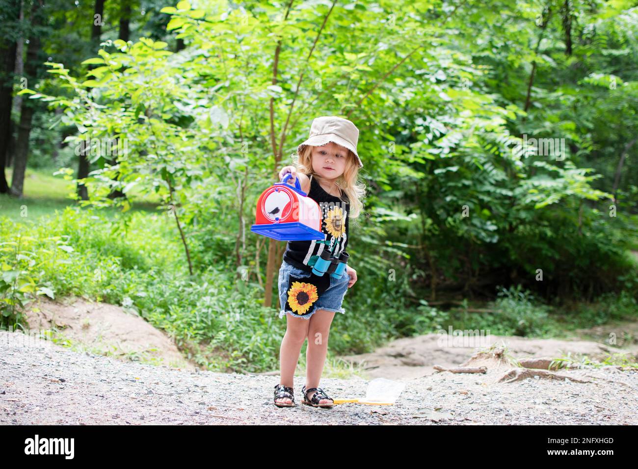 Little caucasian toddler girl caught a bug at the nature walk. Child ...