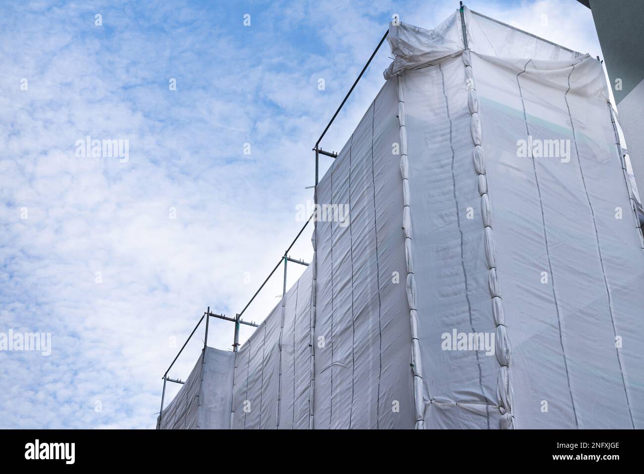 Building site covered in white plastic film. Blue sky with light white ...