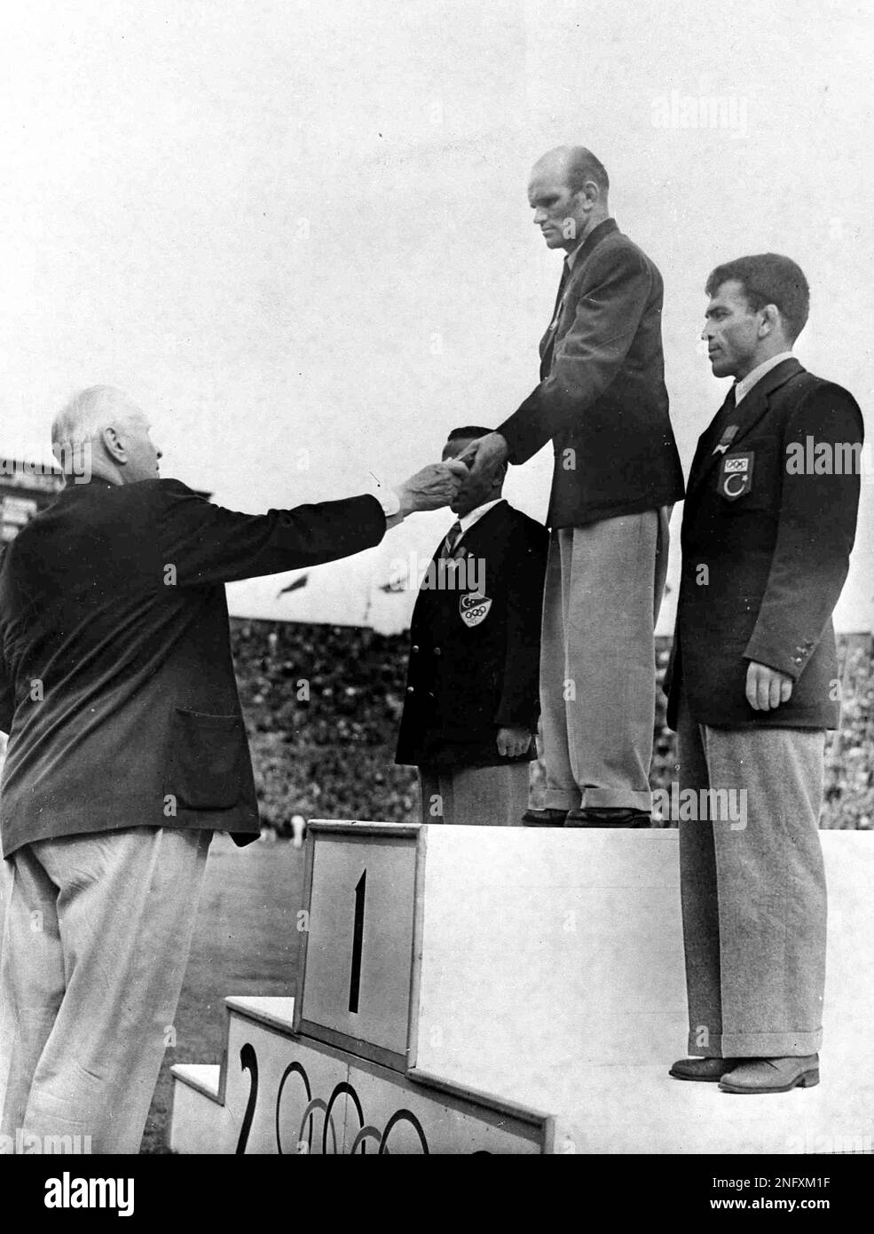 Sweden's Kurt Pettersen, top, receives the gold medal he won in the men ...