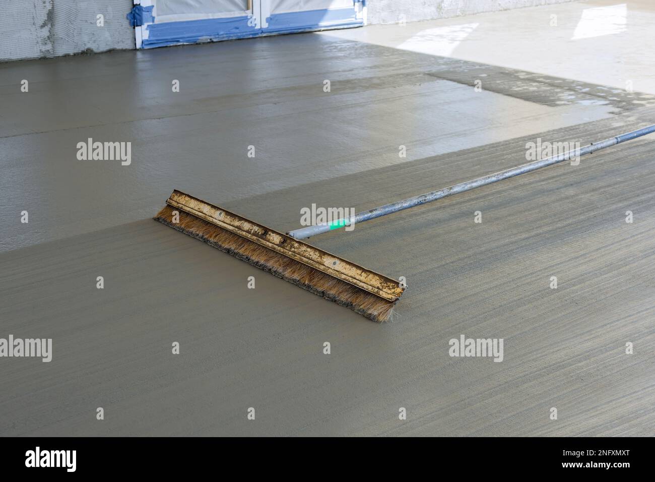 Using broom construction worker brushes fresh wet concrete which causes ...