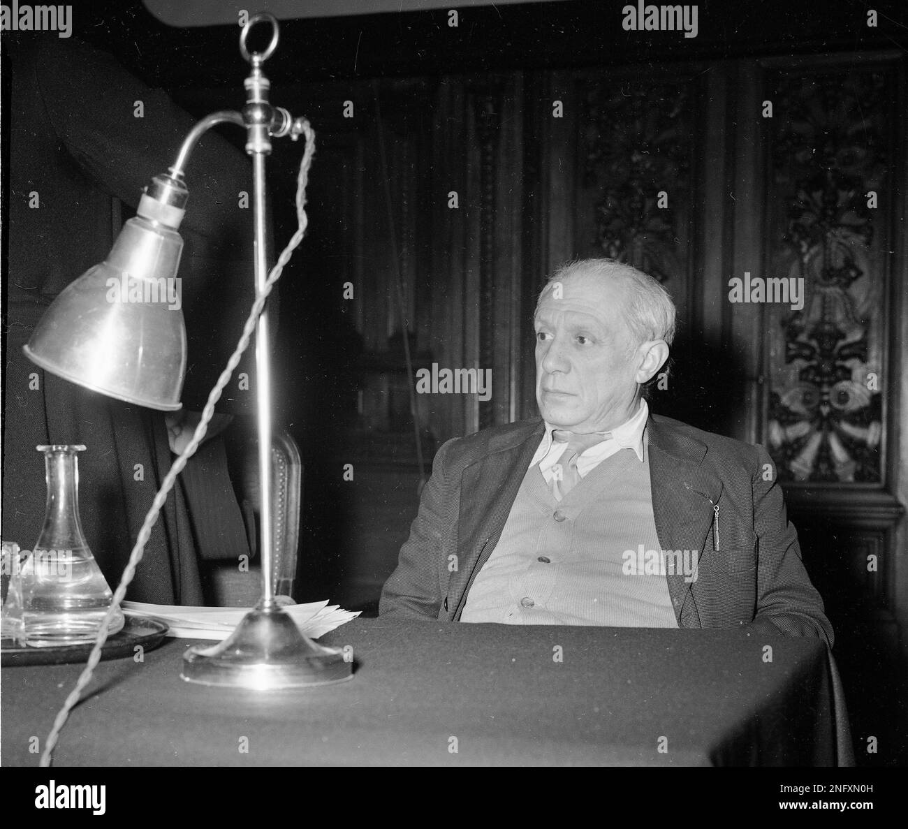 Artist Pablo Picasso sits on the stage at the theater of the Sorbonne ...