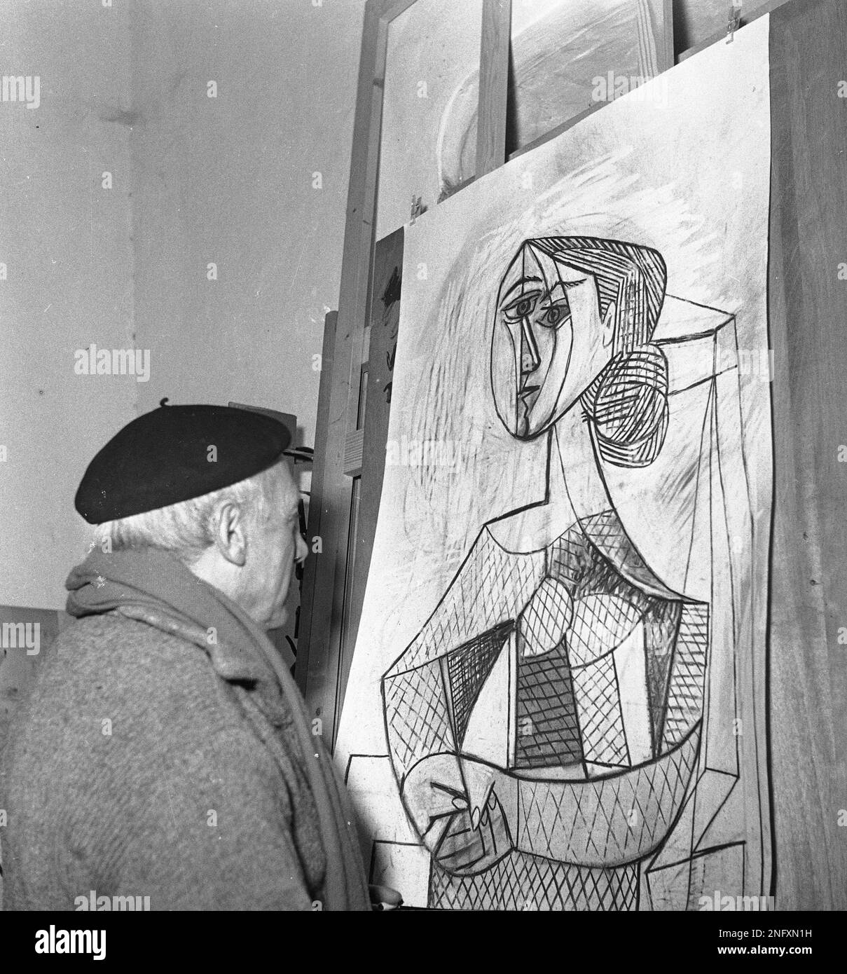 Artist Pablo Picasso looks at a recent painting, "Portrait of a Woman ...