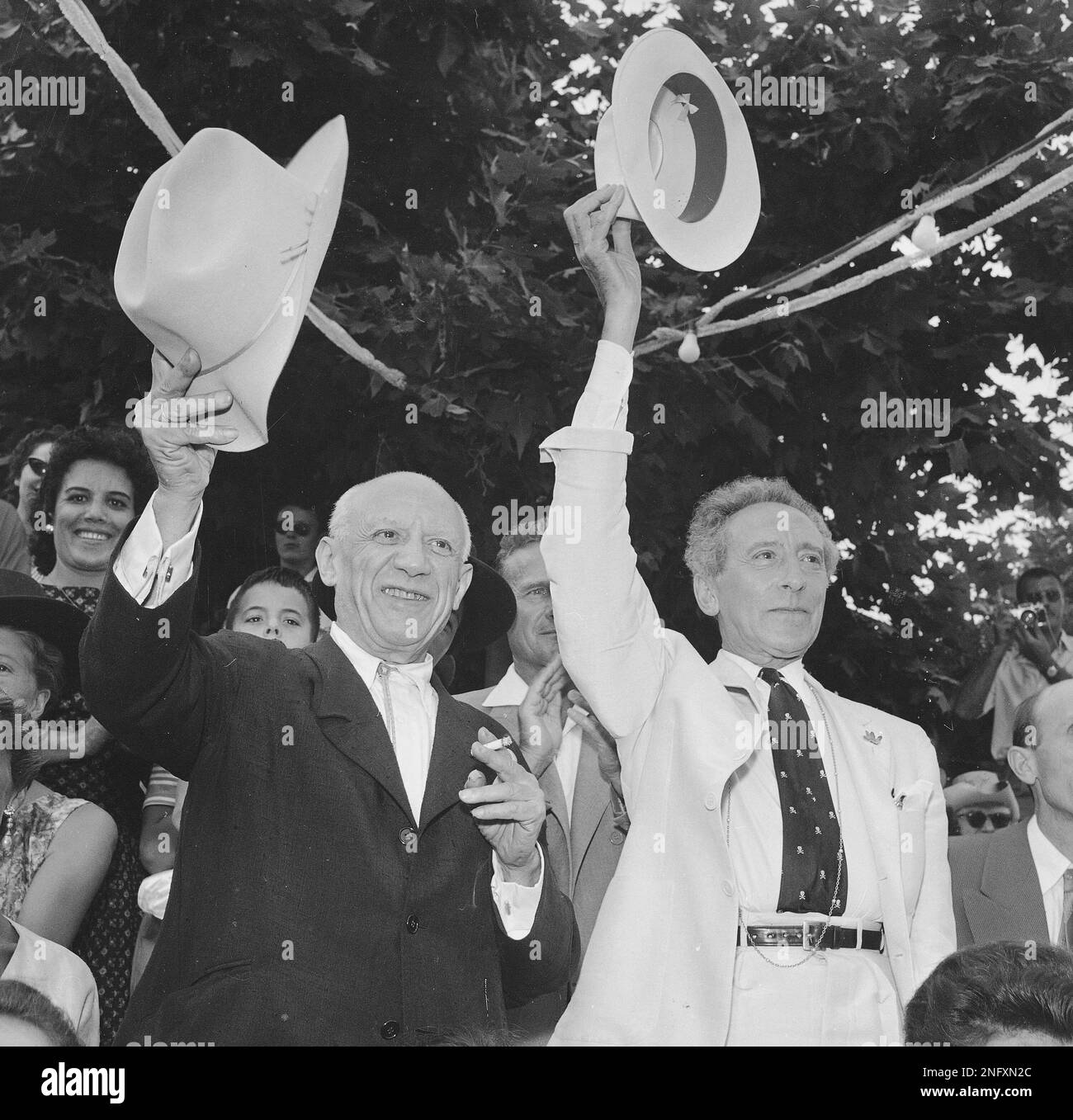 Artist Pablo Picasso, left, and artist and author Jean Cocteau wave ...