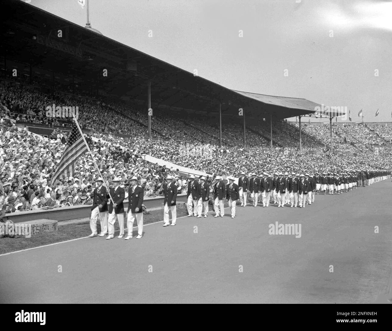 Olympic yachtsman Ralph C. Craig carries the flag in front of the ...