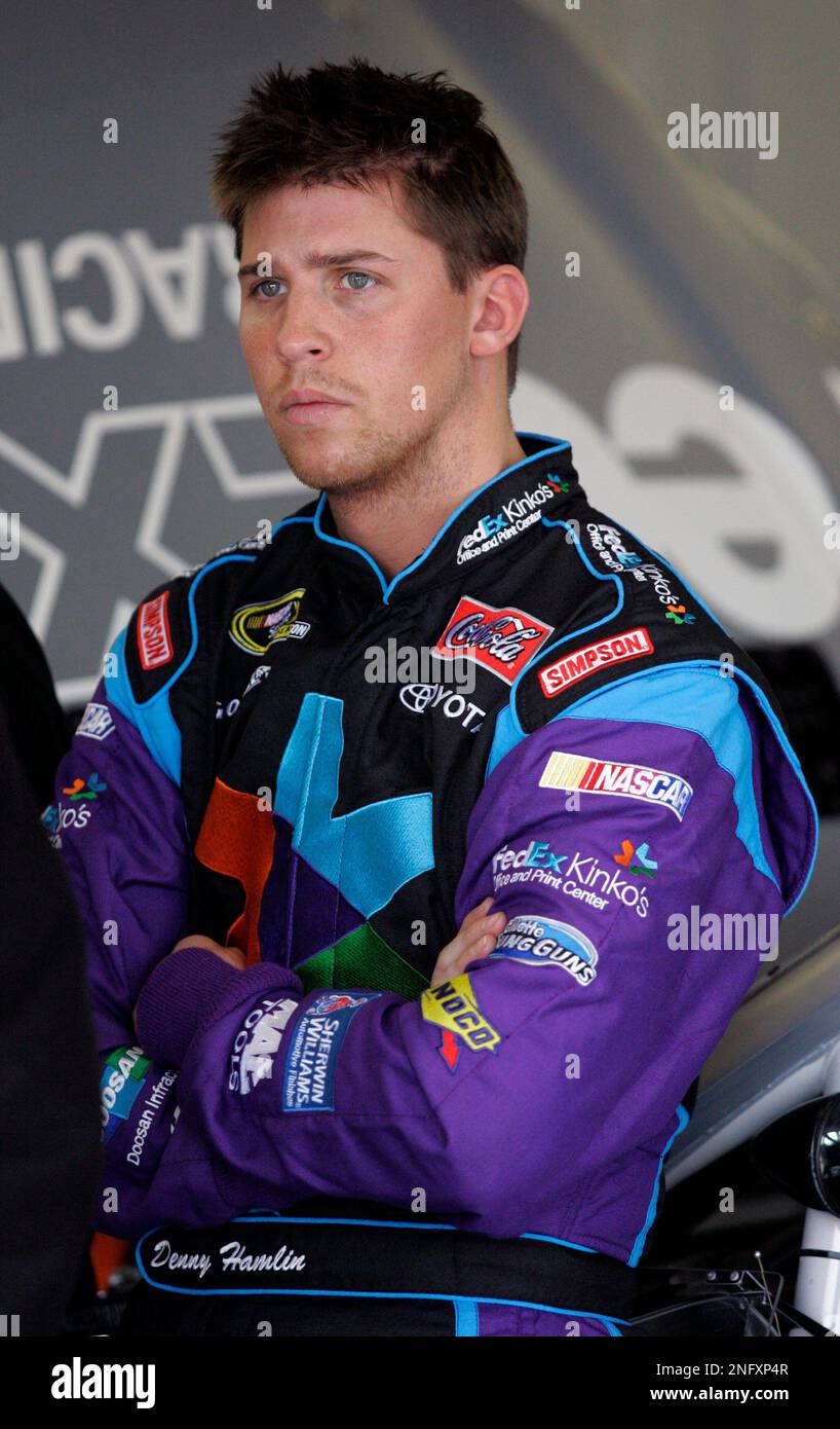 NASCAR driver Denny Hamlin leans on his car as he waits for his crew to ...