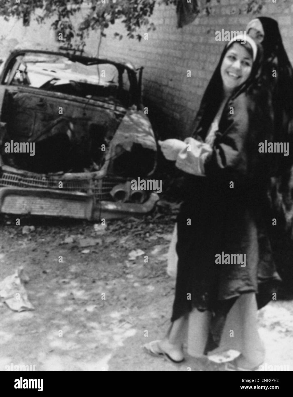 Two young Muslim women dressed in black abayes gowns find something to ...