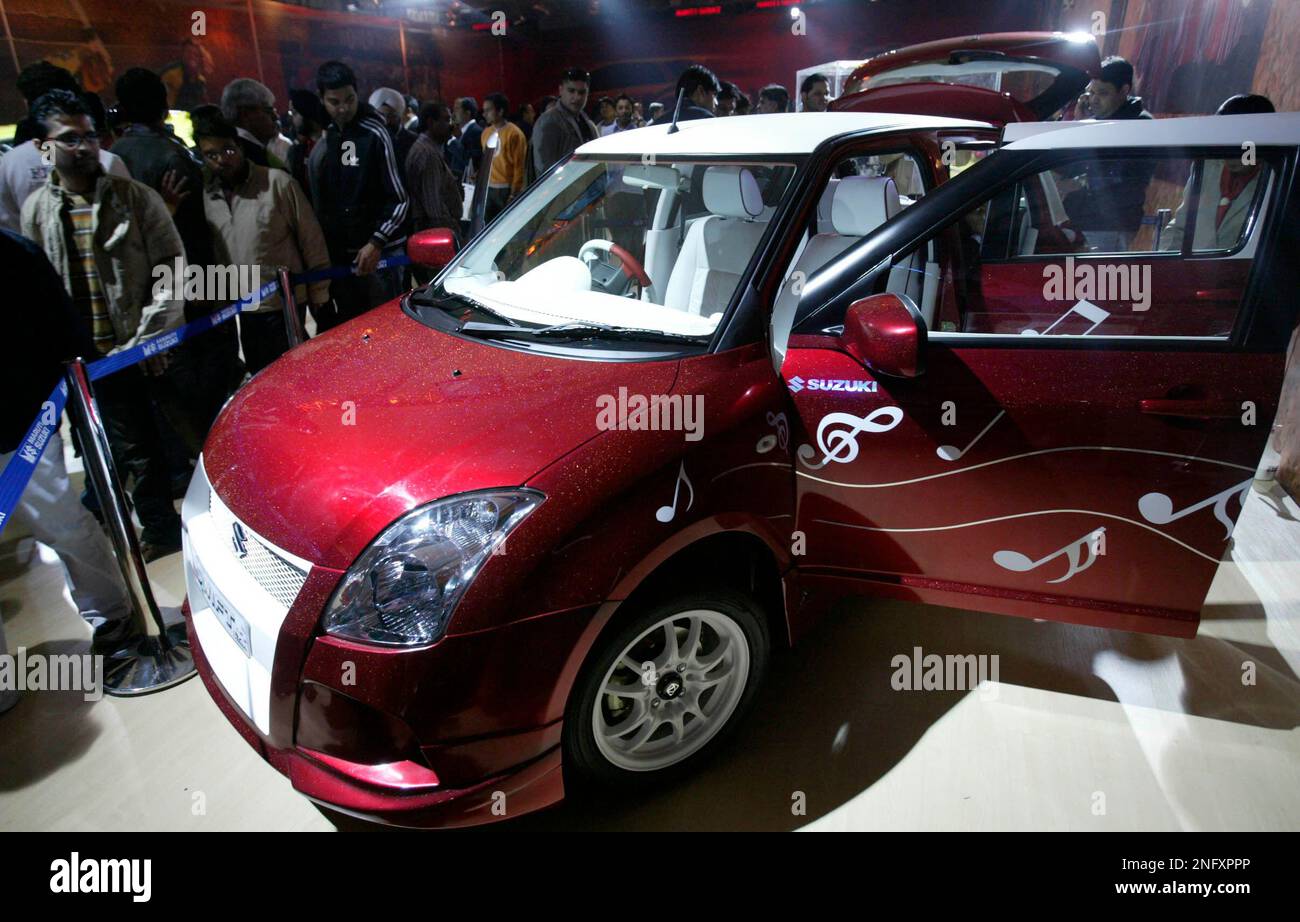 Visitors look at the 'Swift' car at the Maruti Suzuki pavilion of the ...