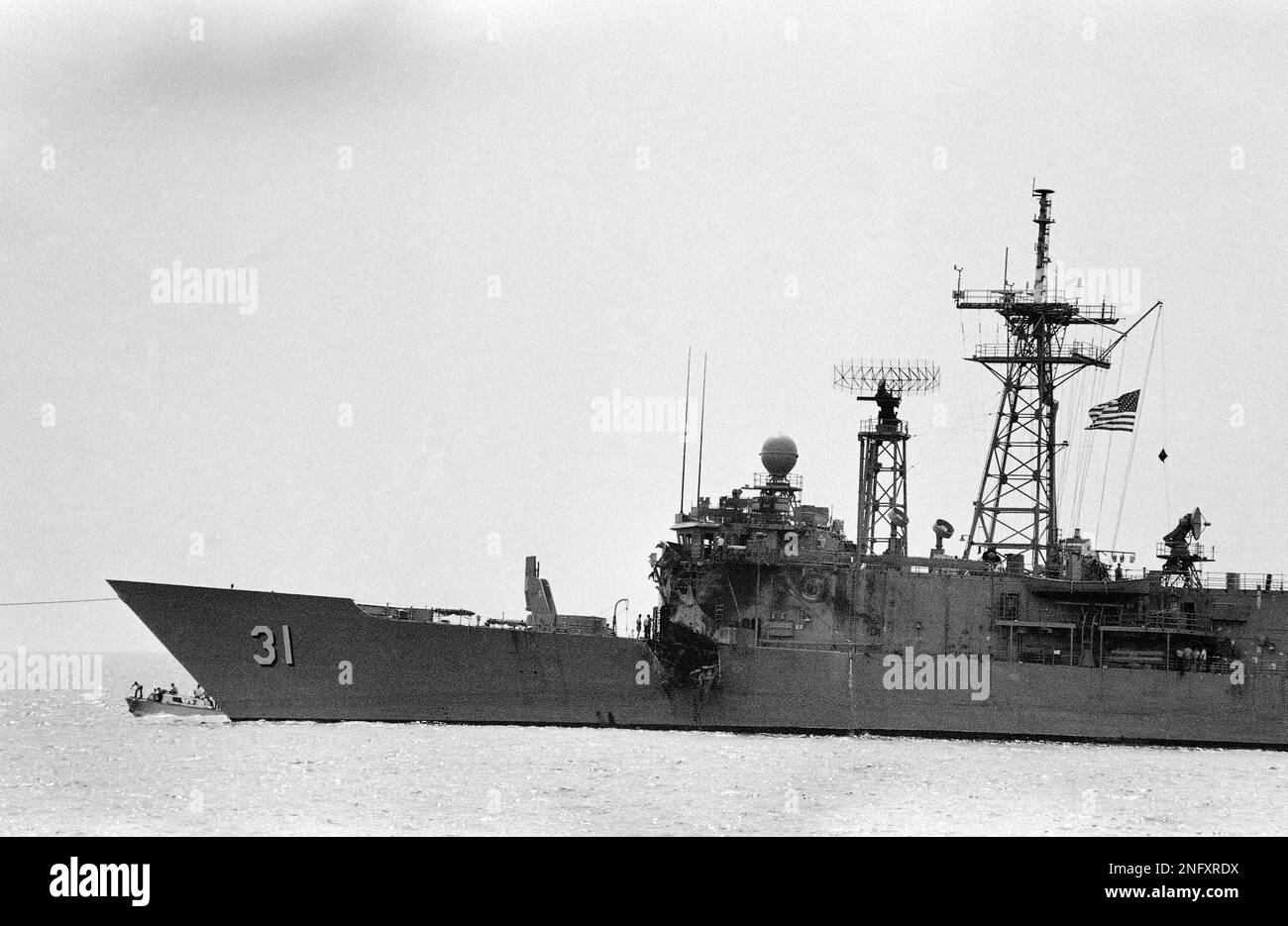 The frigate USS Stark displays a giant hole in her hull below the ...