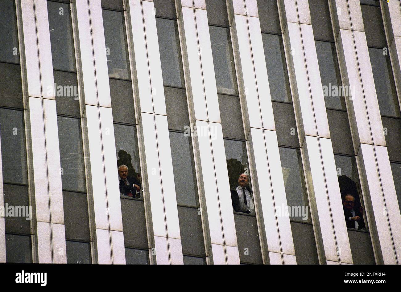 Workers peer through broken windows of the World Trade Center in New ...